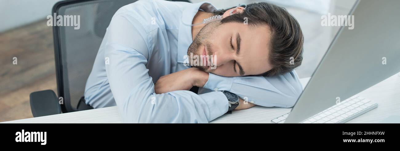 exhausted security man sleeping at workplace near computer monitor ...