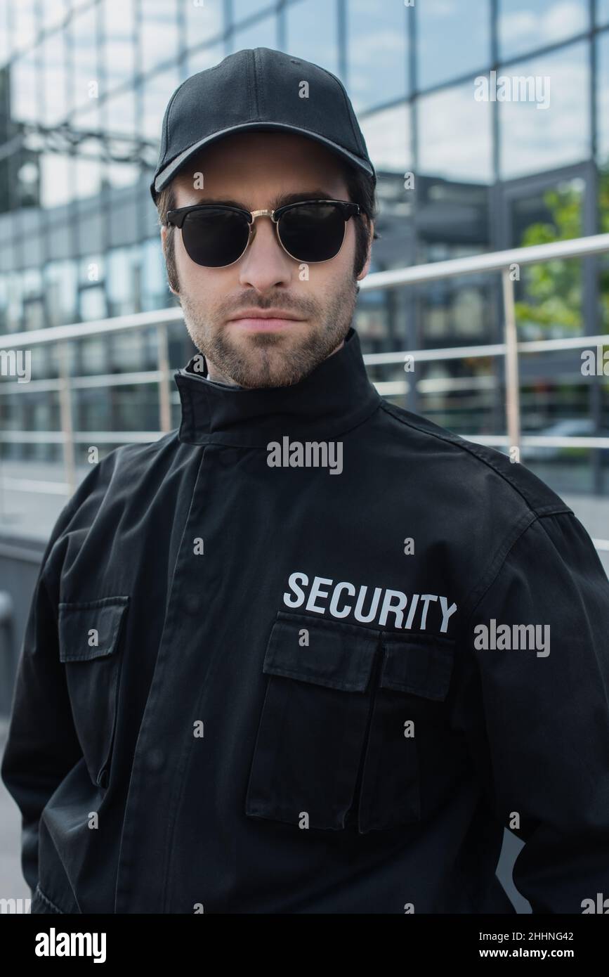 security man in black uniform and sunglasses looking at camera outdoors ...