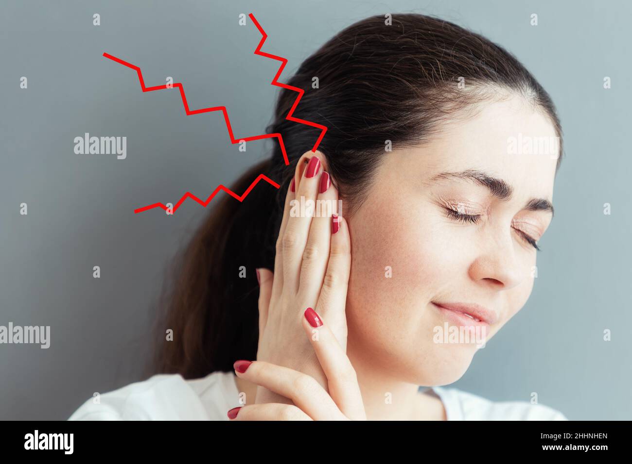 Portrait of a suffering young Caucasian woman covering her ear with her ...