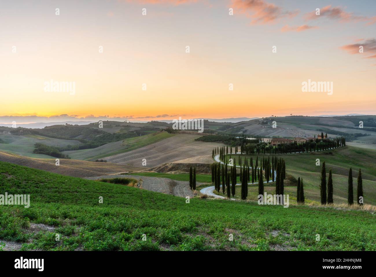 Tuscany, rural landscape at sunset. Rural farm, cypresses, green field ...