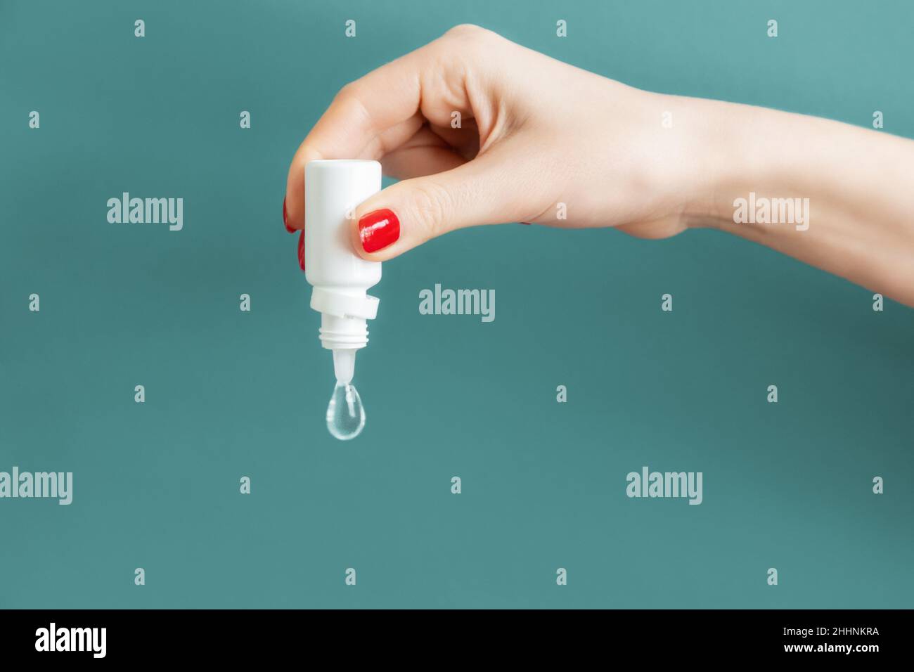 A beautiful female hand with a red manicure holds the medicine ...