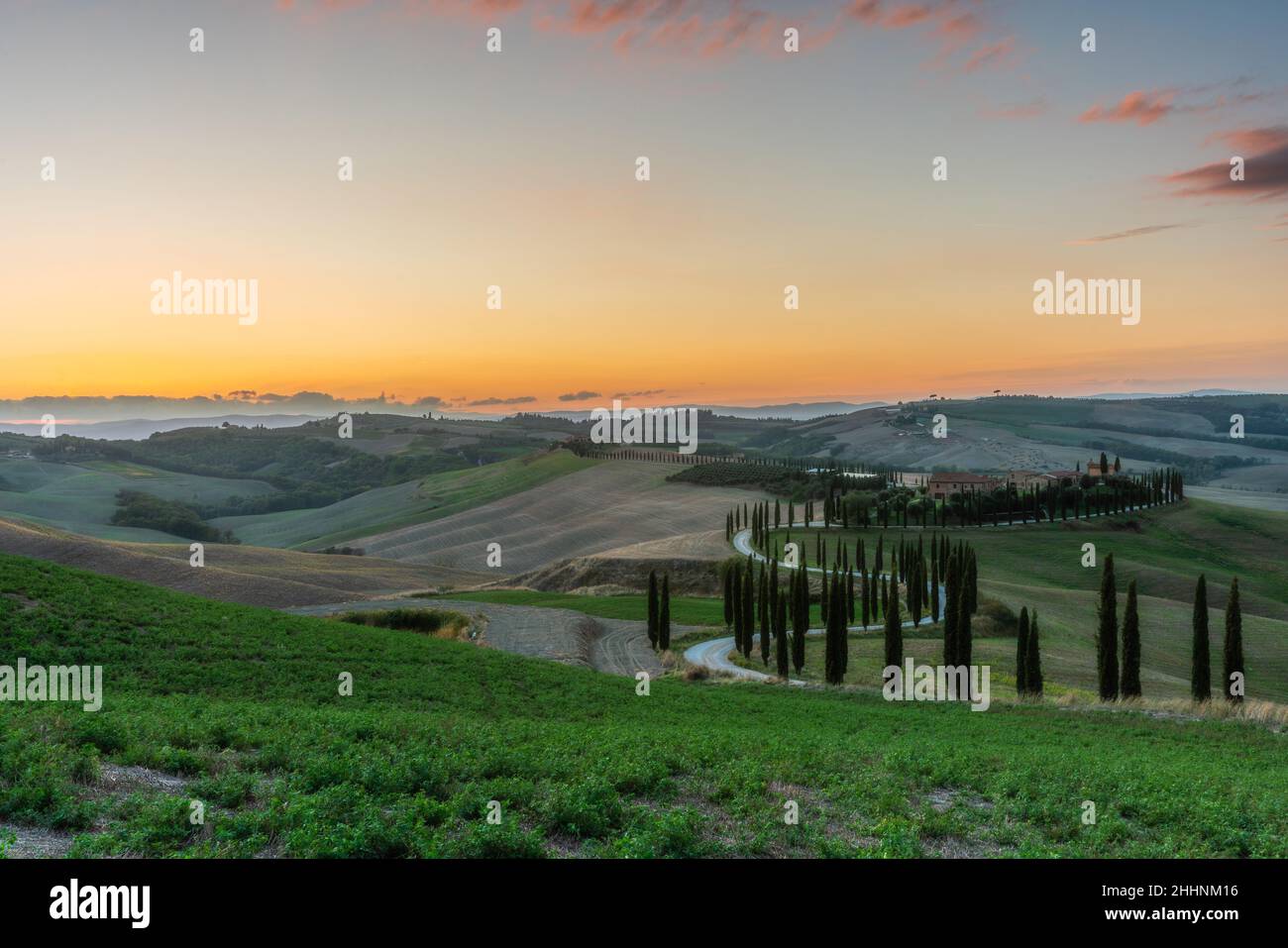 Tuscany, rural landscape at sunset. Rural farm, cypresses, green field ...