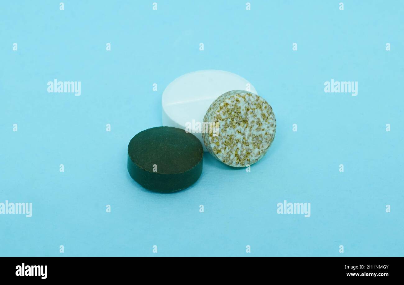 Green, white and mottled tablets lie on a blue background Stock Photo ...