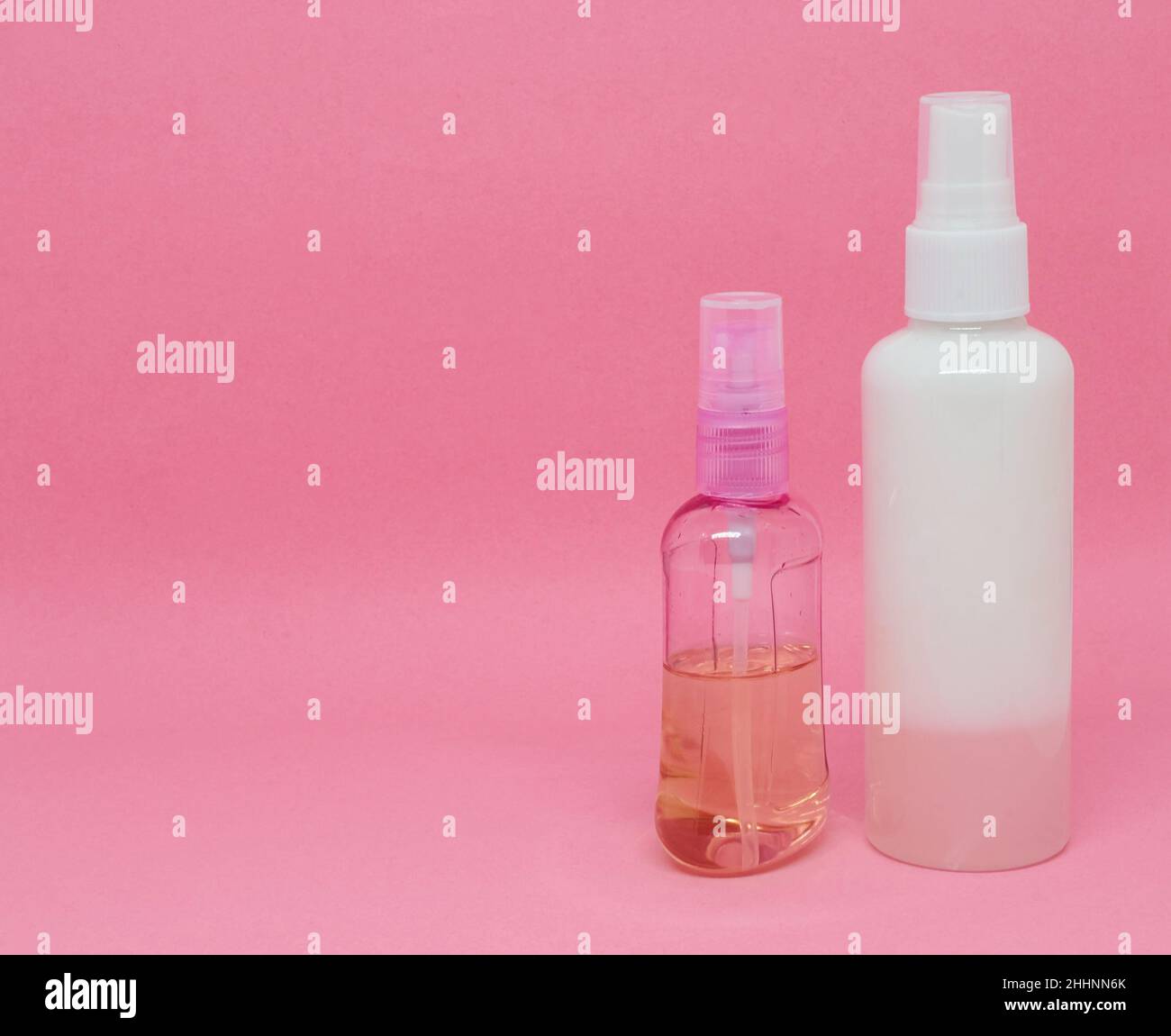 Two spray bottles on a pink background Stock Photo - Alamy