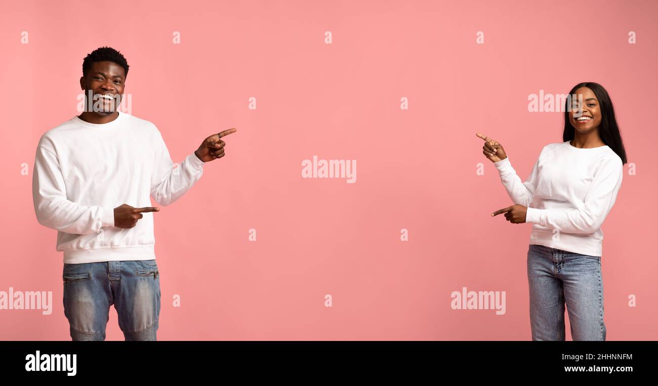 Happy black man and woman showing empty space between them Stock Photo ...