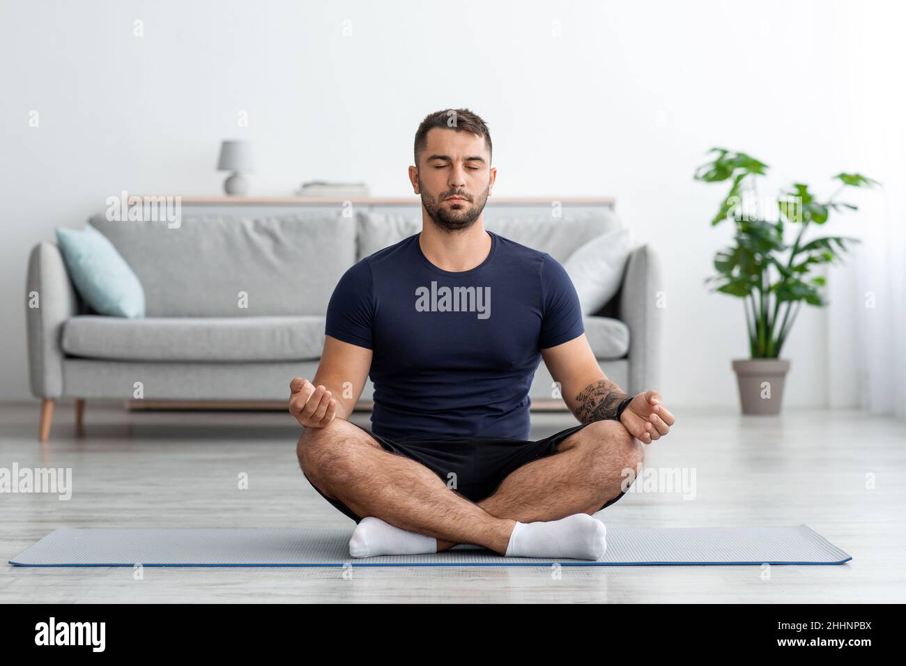 Serious calm concentrated young caucasian muscular man with closed eyes ...