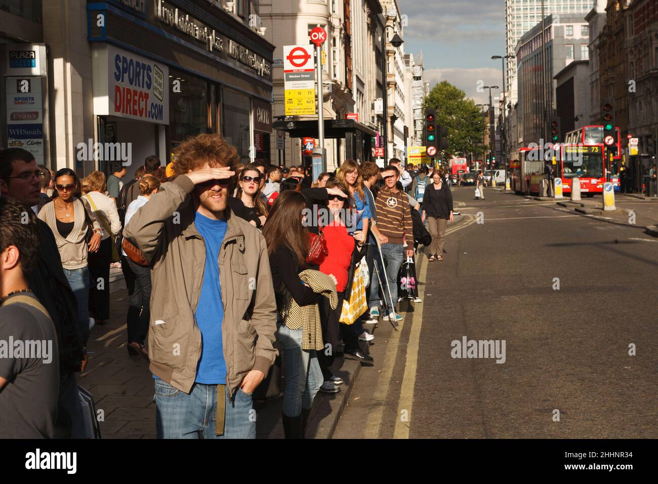 Large crowd of commuters queuing at a bus stop. The large crowds was ...