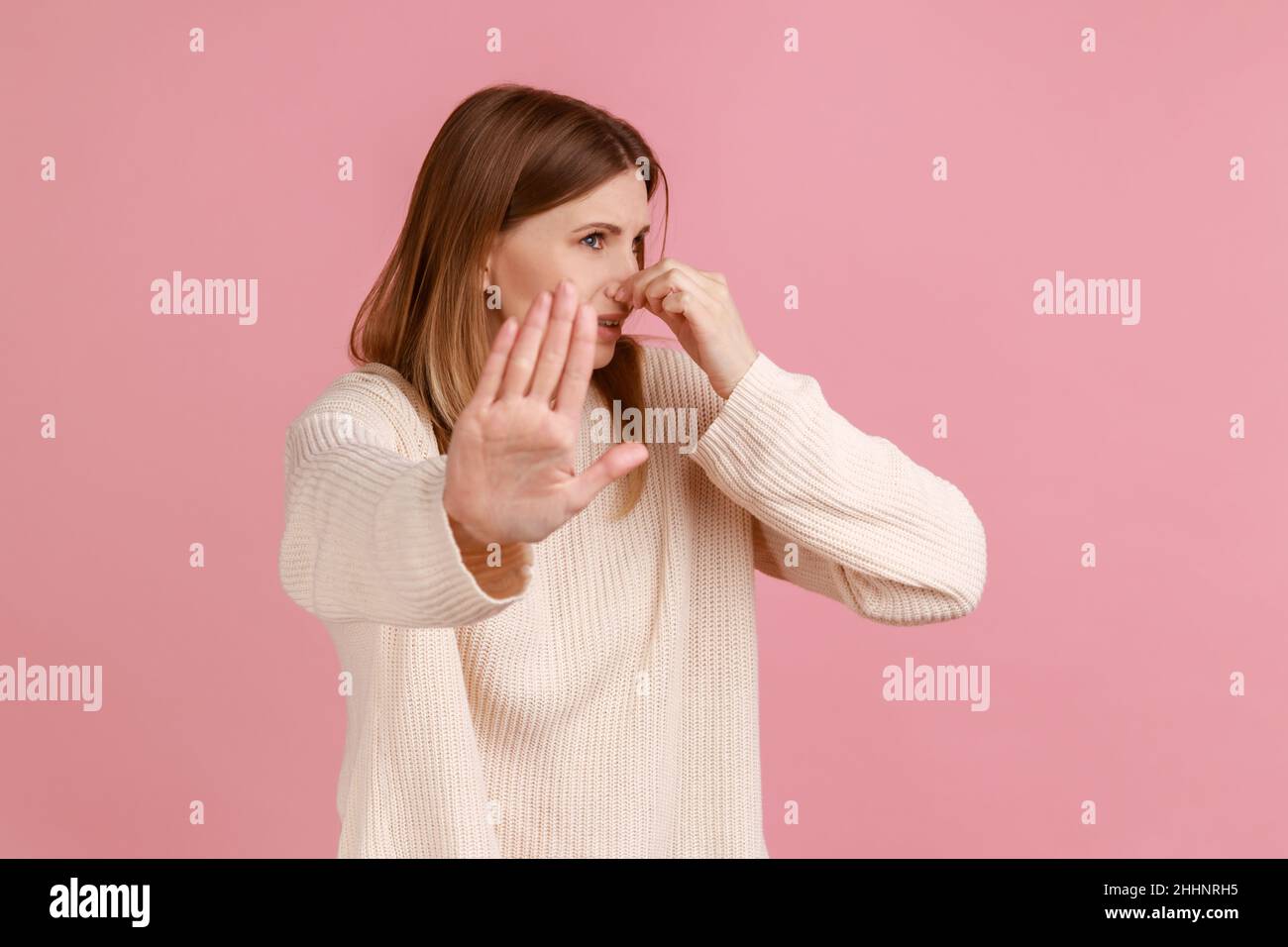 Portrait of woman pinching her nose, holding breath to avoid bad smell ...