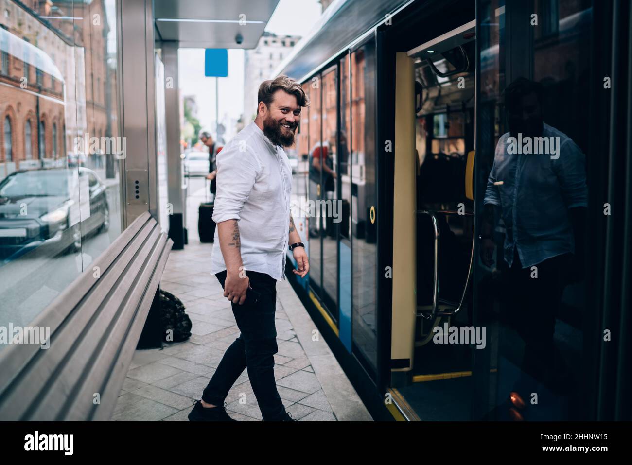 Smiling man going inside modern transport Stock Photo - Alamy