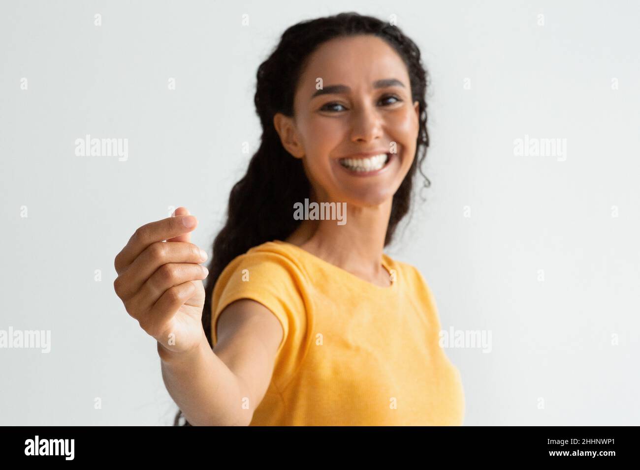 Happy Lady Holding Invisible Object In Hand And Showing It At Camera ...