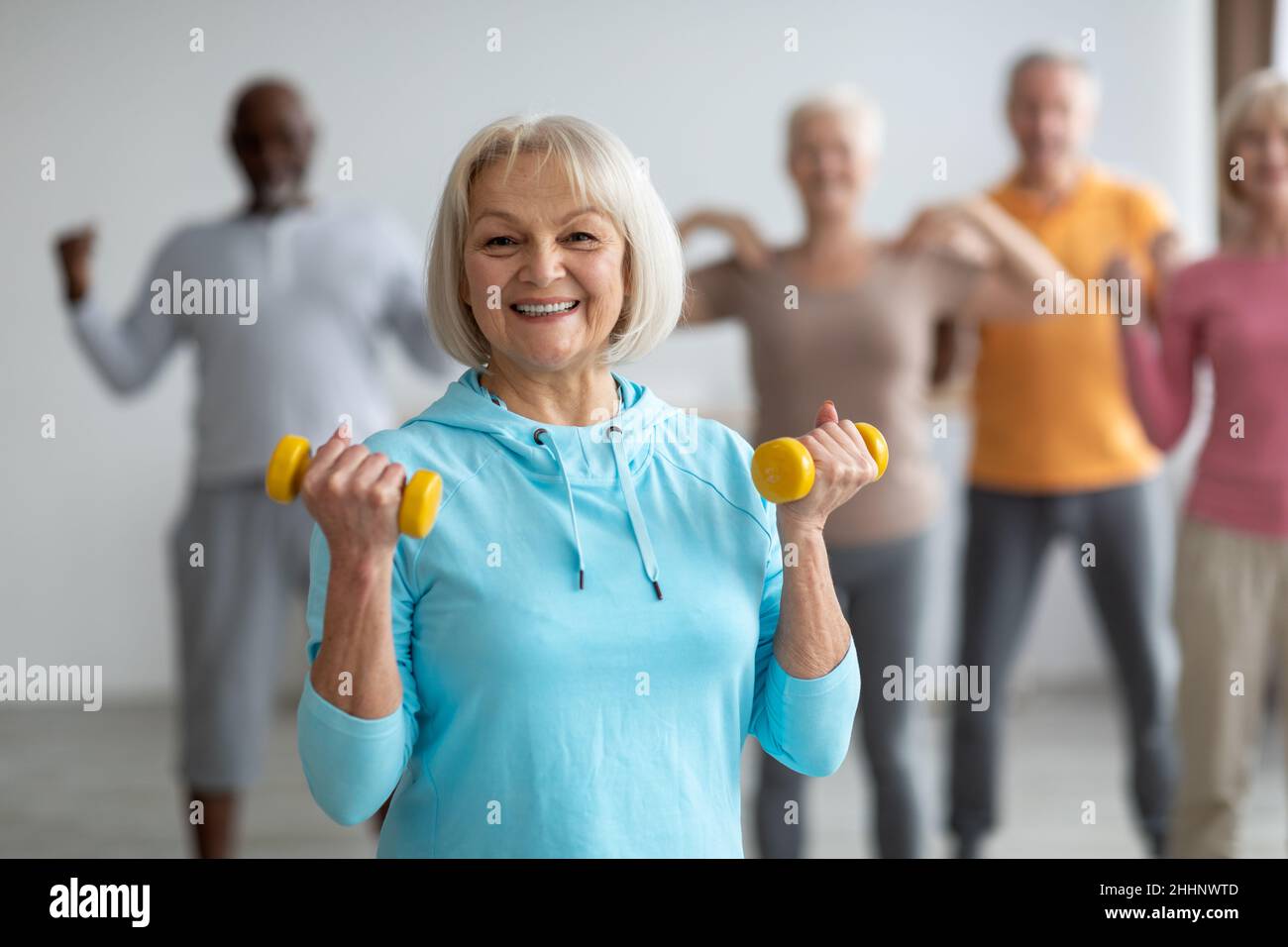 Seniors doing strength building fitness exercises with dumbbells Stock ...
