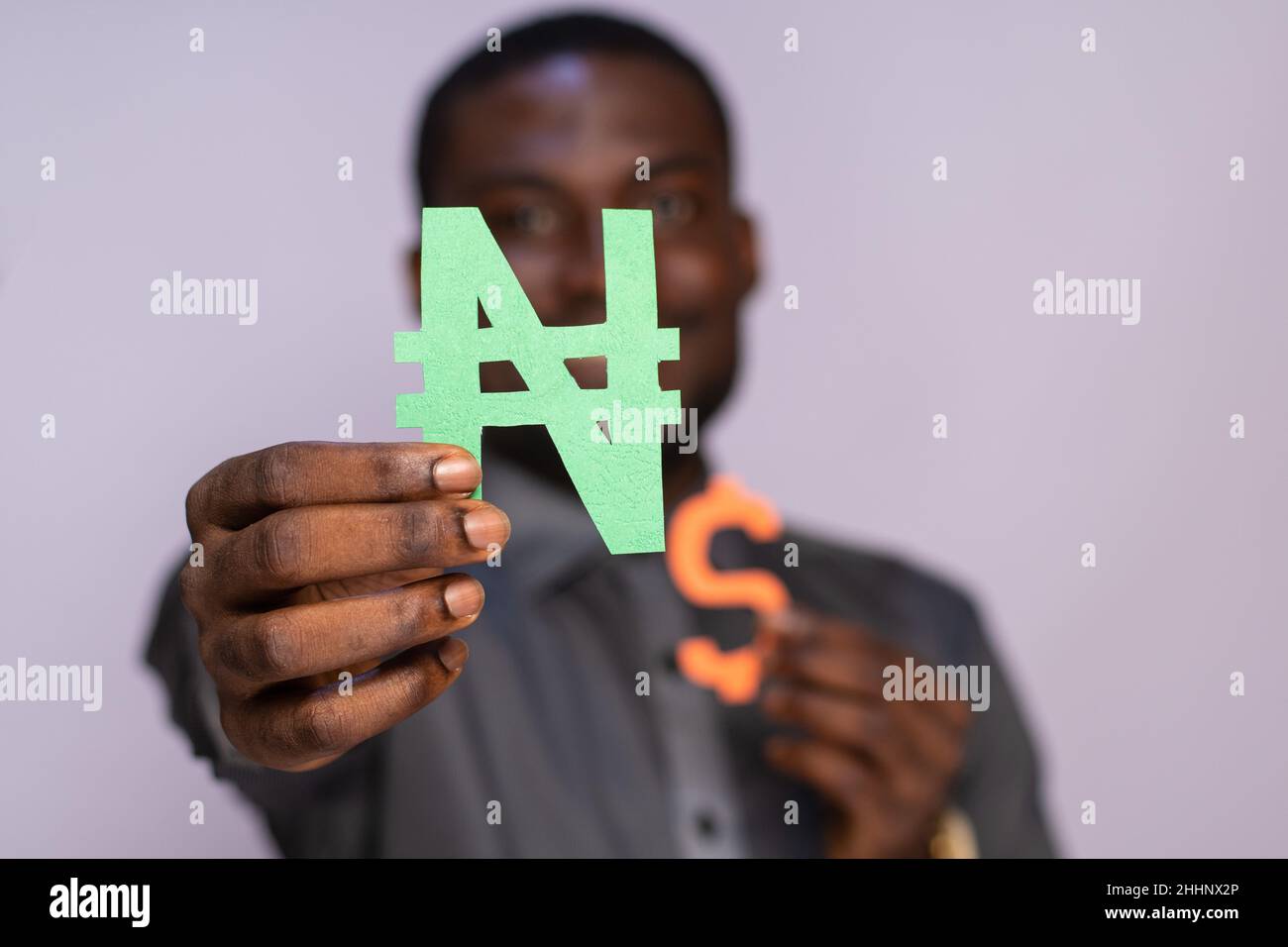 Nigerian man holding a naira symbol over a dollar symbol Stock Photo ...