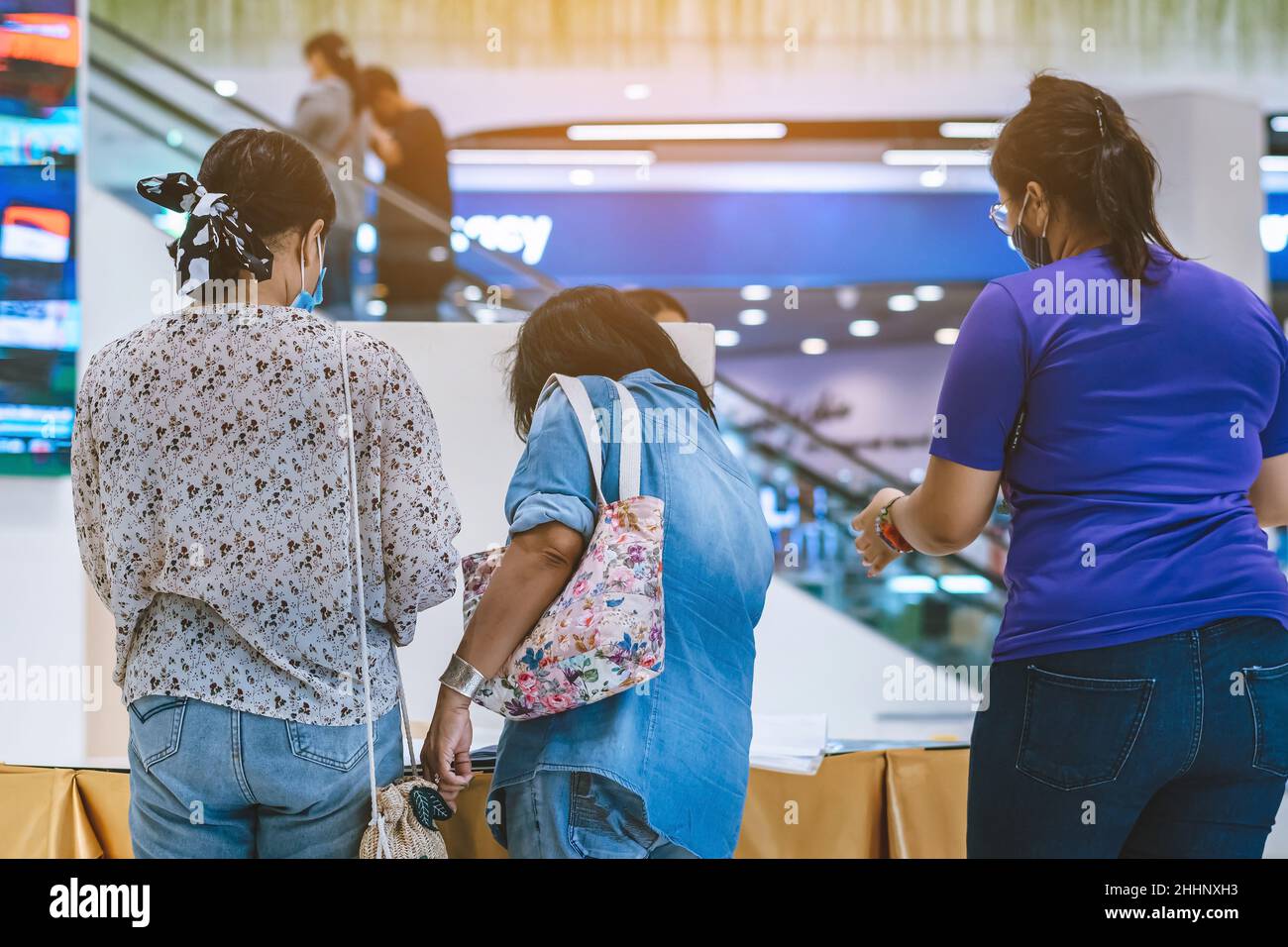 Back view of Asian customer wear face mask register their identity by ...