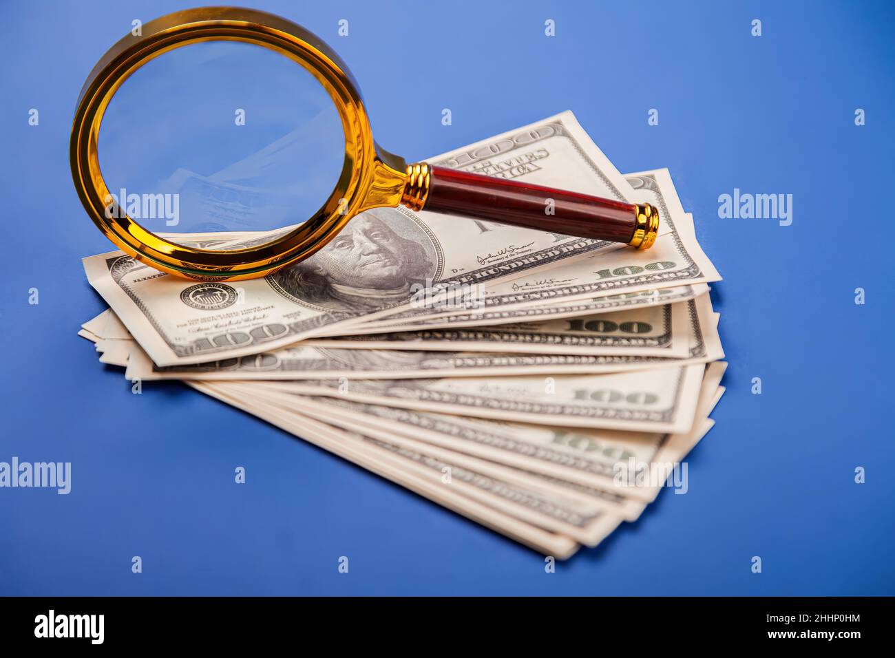 Money with a magnifying glass. Finding profits and losses. A business ...