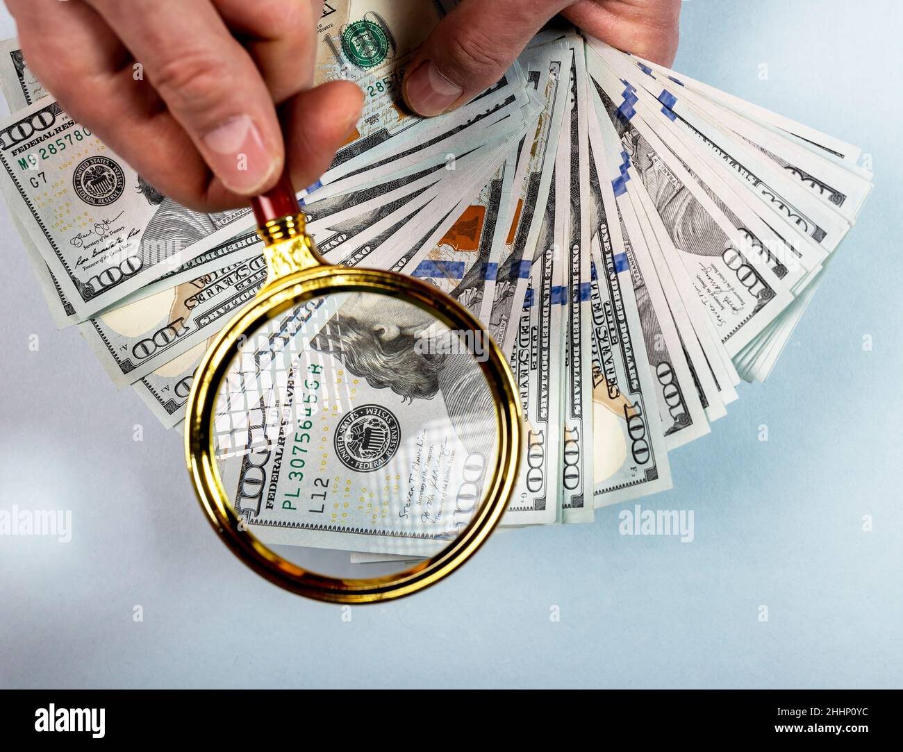 Inspection of dollar banknote through magnifying glass Stock Photo - Alamy