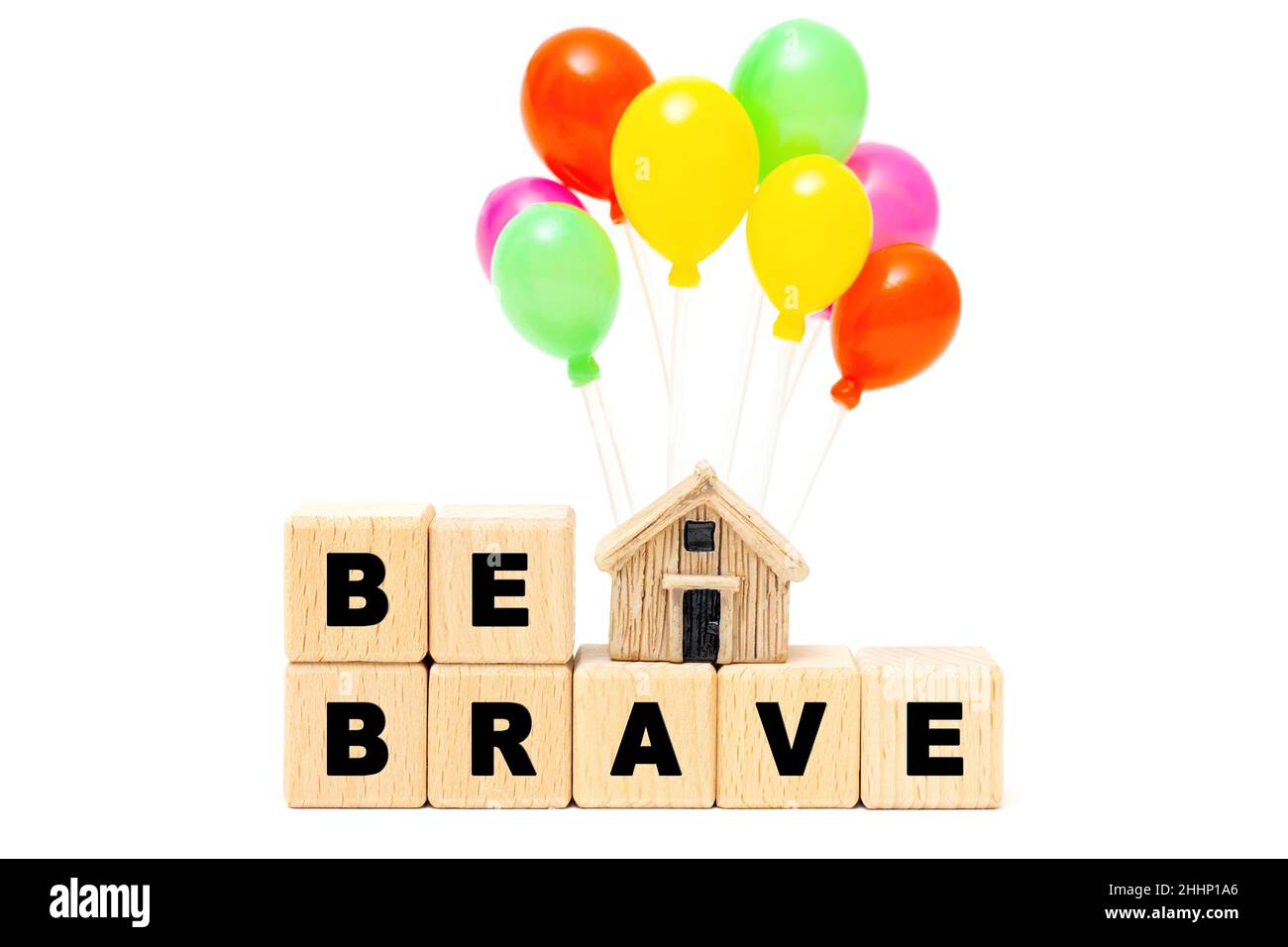Text BE BRAVE made from wooden letter blocks and a miniature house ...