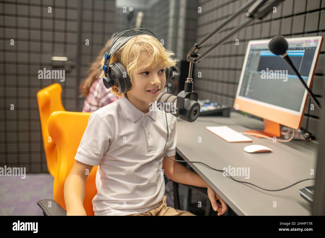 Pleased boy concentrated on recording a podcast in the studio Stock ...