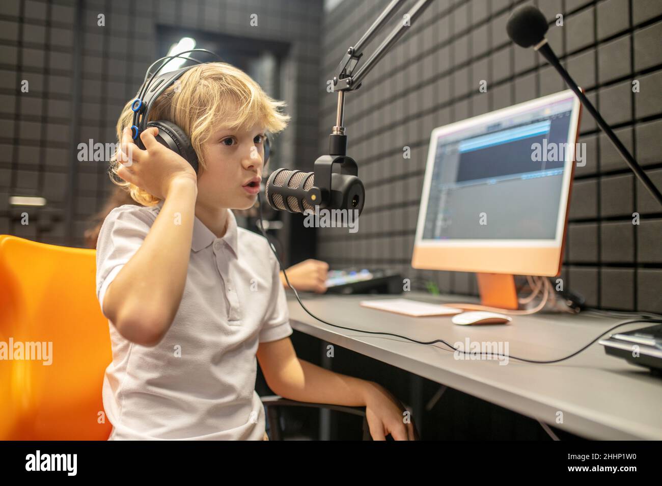 Focused kid broadcasting a program from the radio station Stock Photo ...