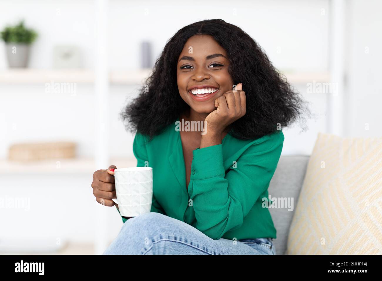 Cheerful pretty african american lady chilling at home, drinking coffee ...