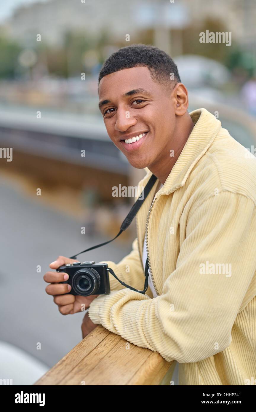 Man smiling at camera leaning on railing in street Stock Photo - Alamy