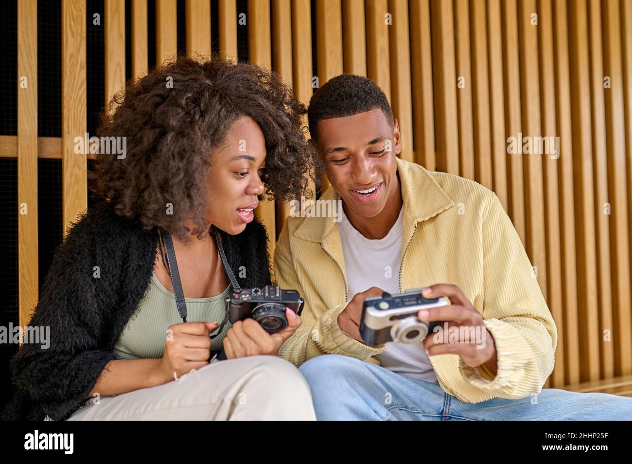 Man showing camera to woman sitting outdoors Stock Photo - Alamy