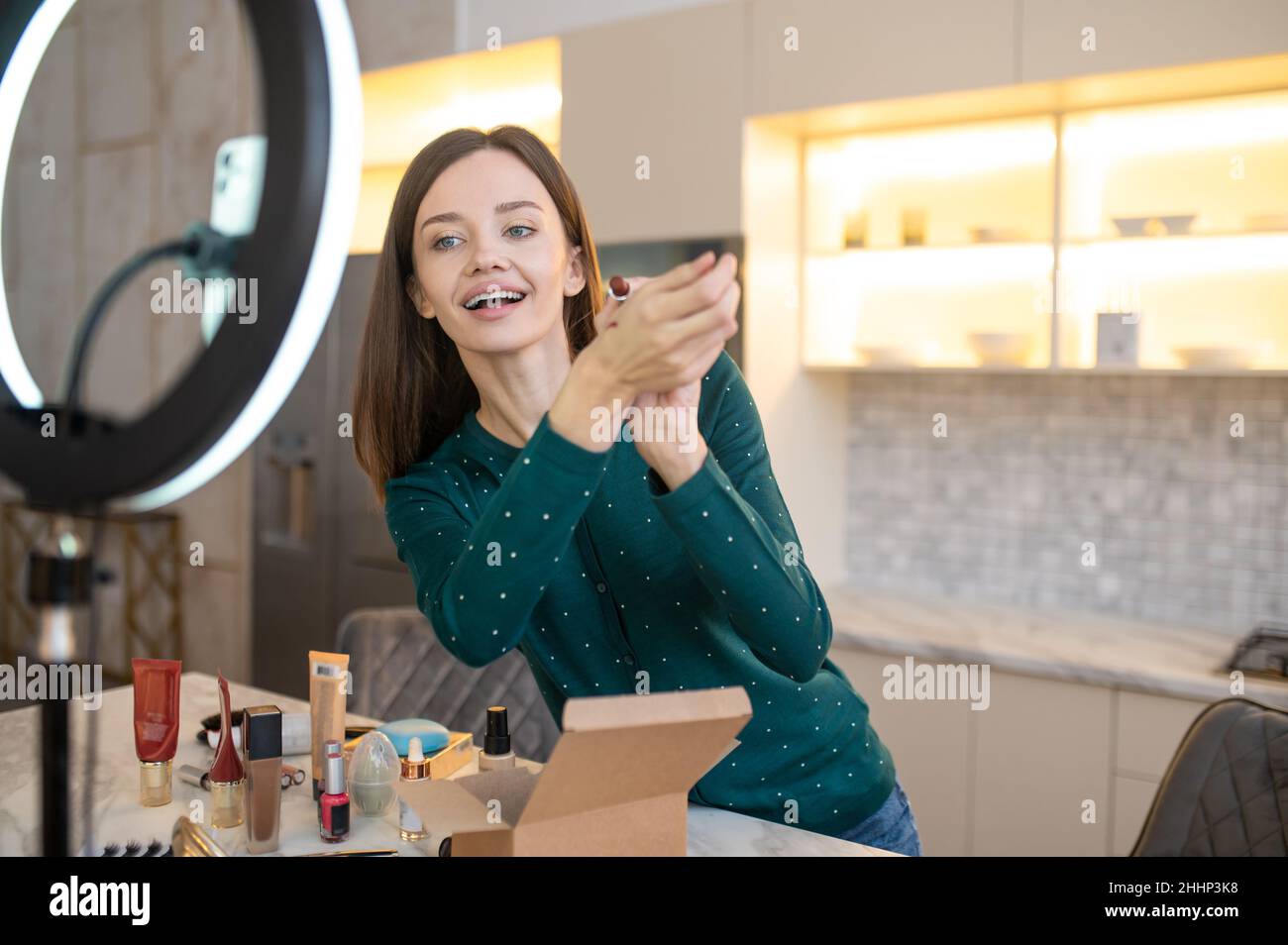 Pretty woman demonstrating new cosmetics and looking involved Stock ...