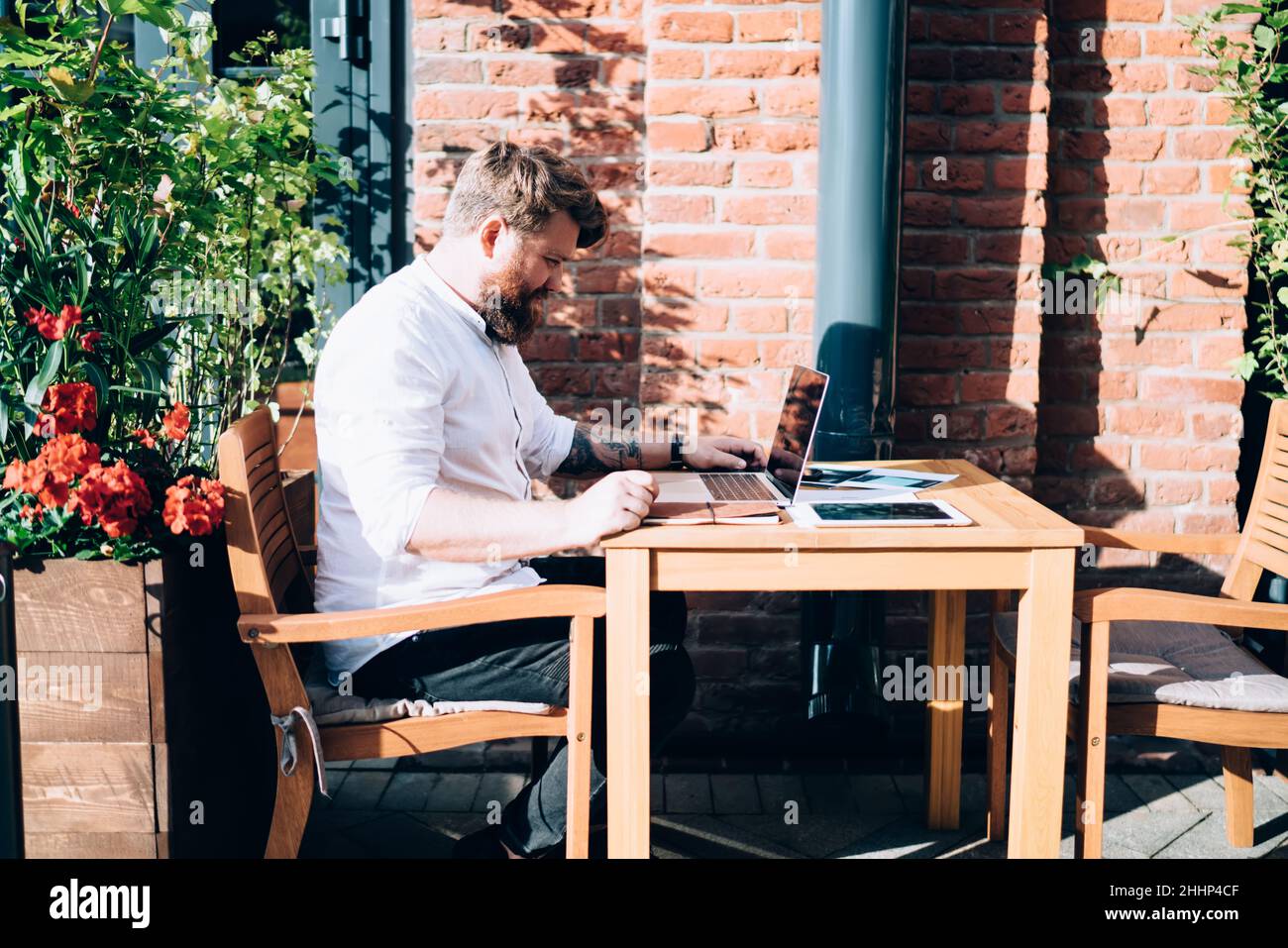 Serious man using laptop while working outside Stock Photo - Alamy