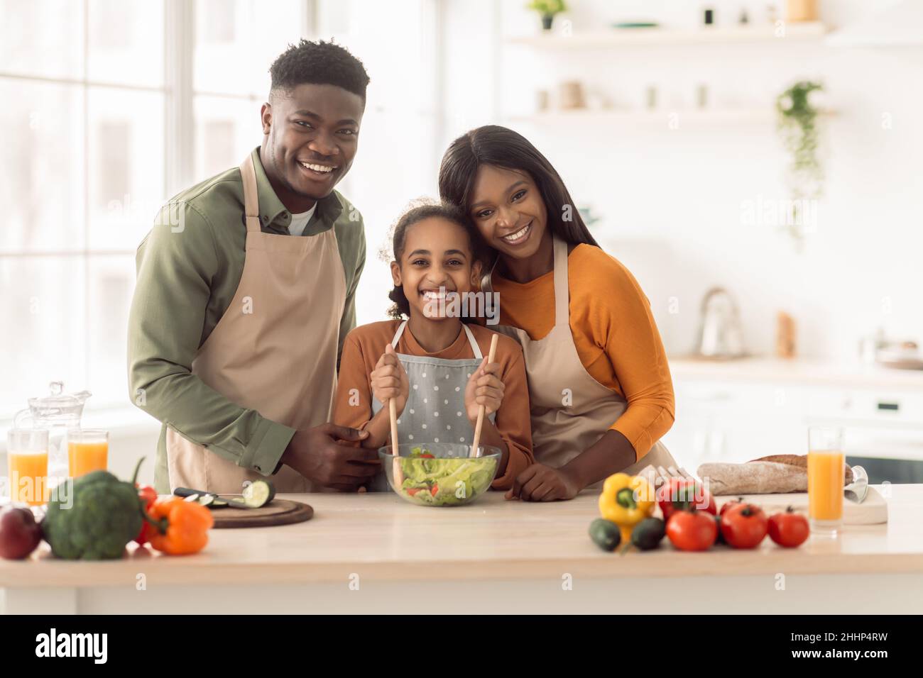 Happy Black Parents And Daughter Cooking Hugging In Modern Kitchen ...