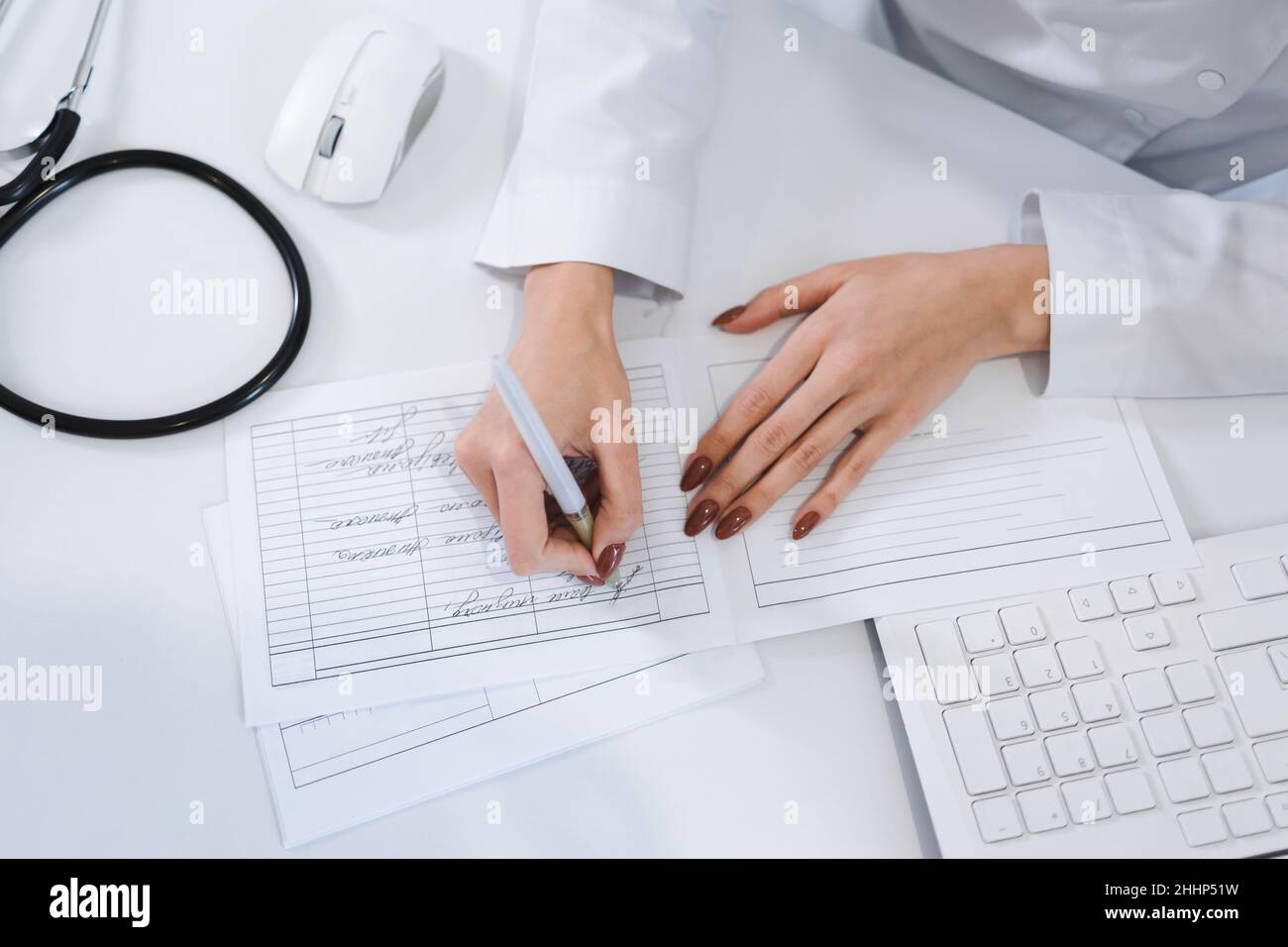Close up view of female doctor hands filling paperwork Stock Photo - Alamy