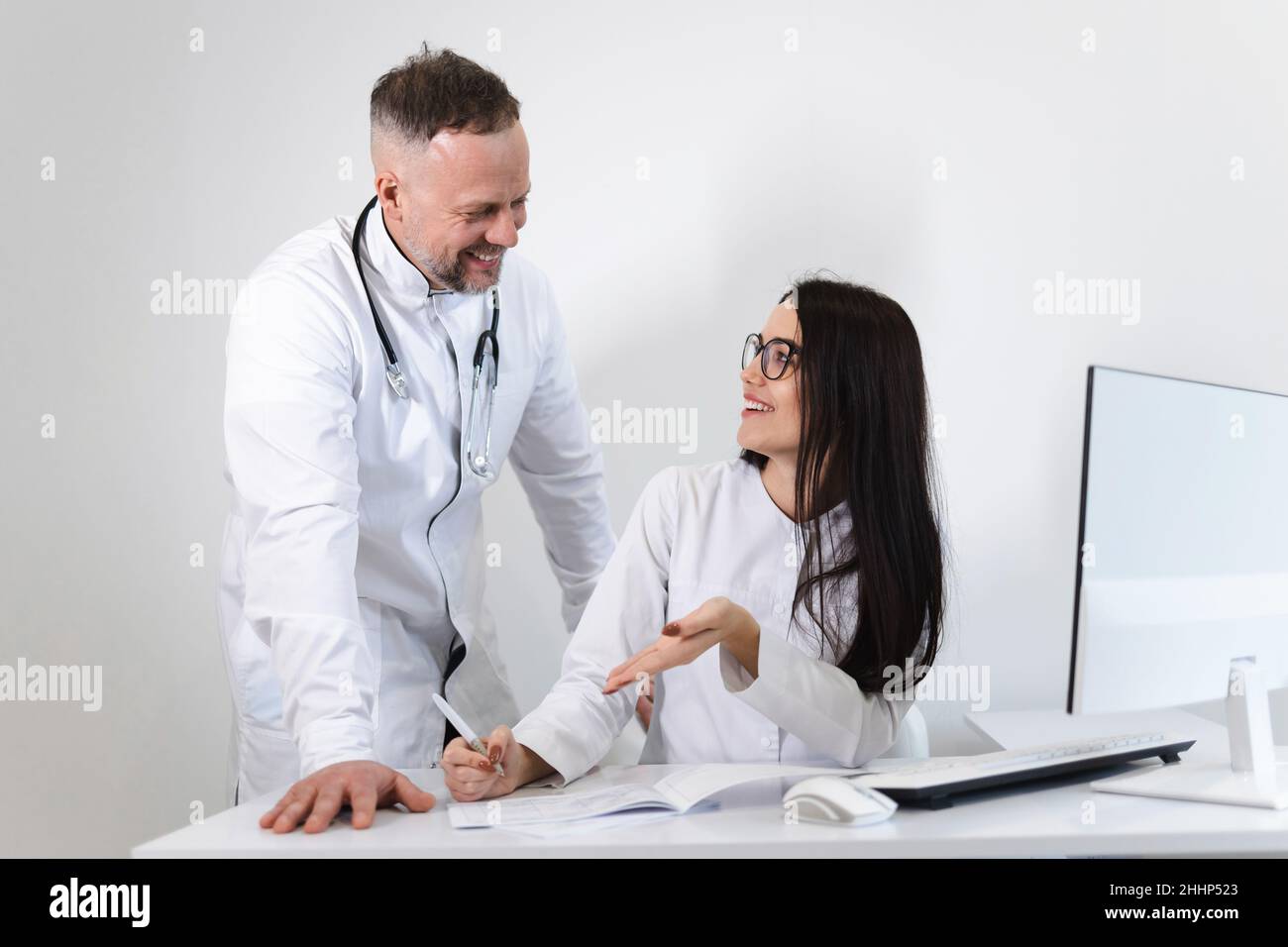 Young female medical worker consults with the male head physician. Two ...