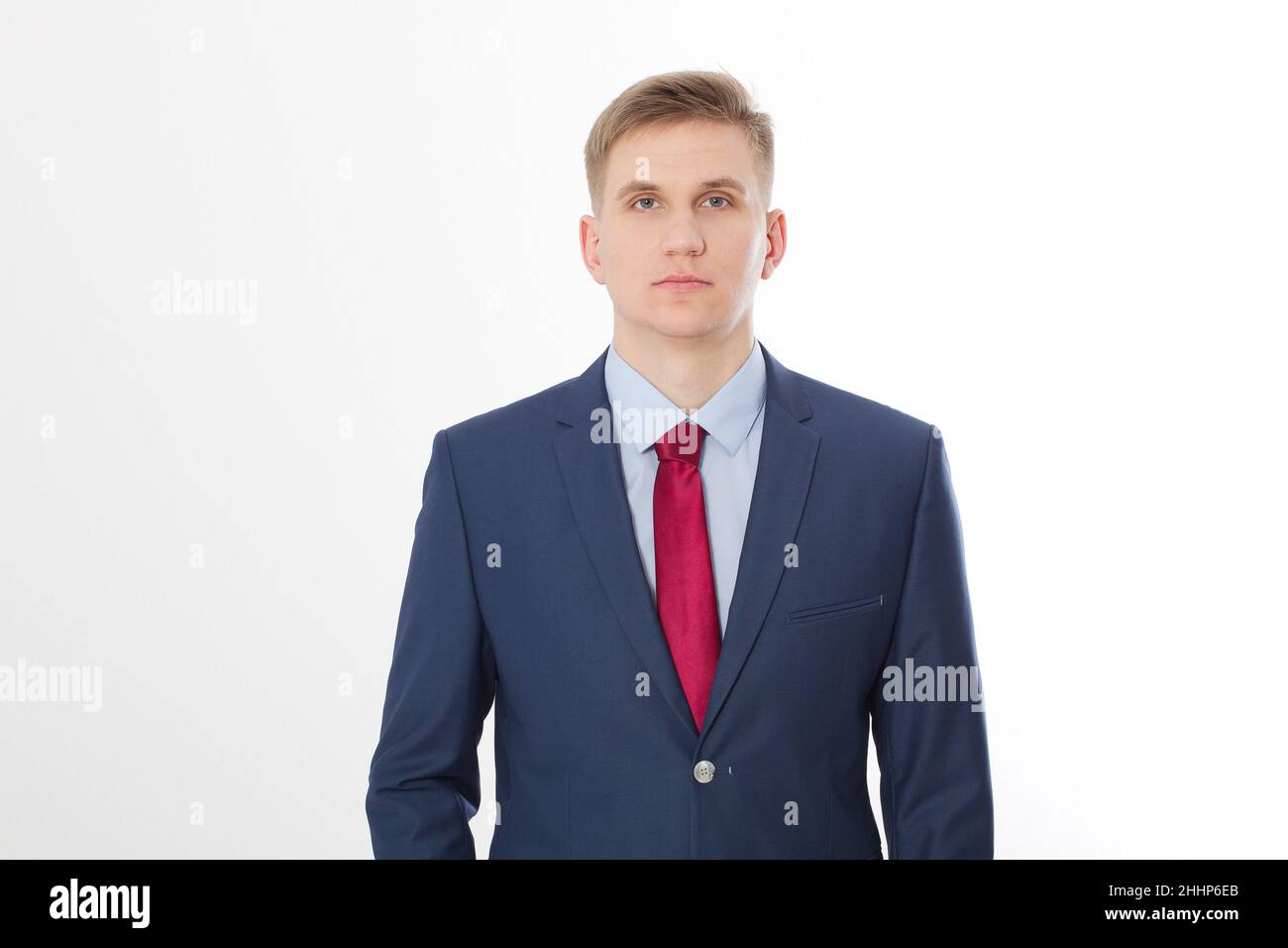 Serious businessman in blue suit and red tie isolated on white ...