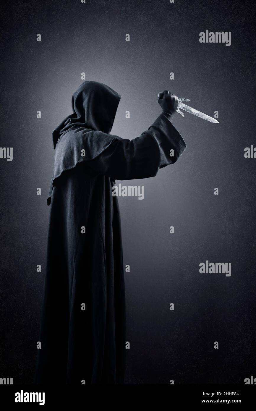Hooded man with dagger in the dark Stock Photo - Alamy