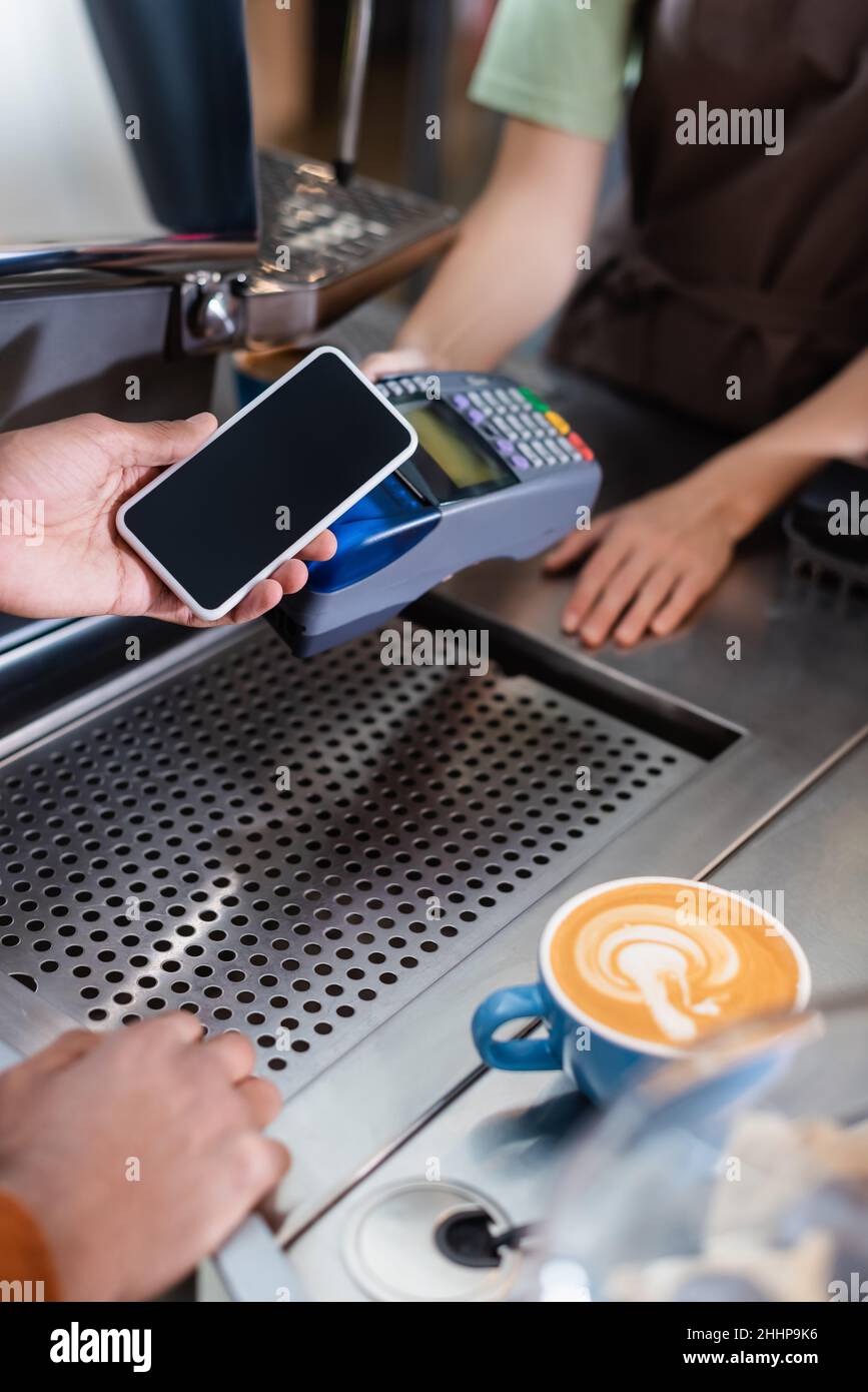 Cropped view of african american customer paying with cellphone near ...