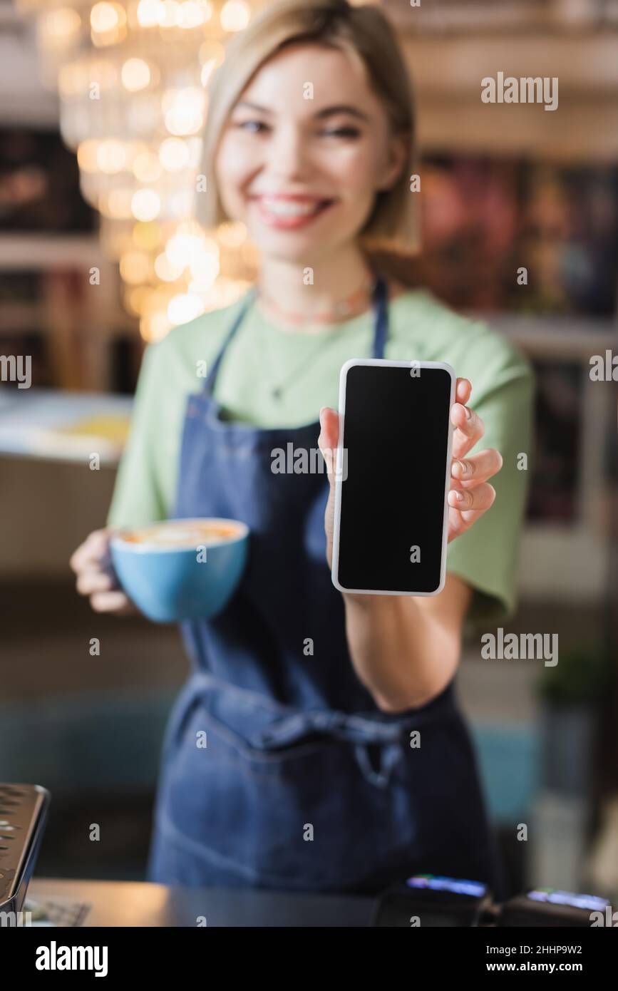 Cellphone with blank screen in hand of barista with cup in cafe Stock ...
