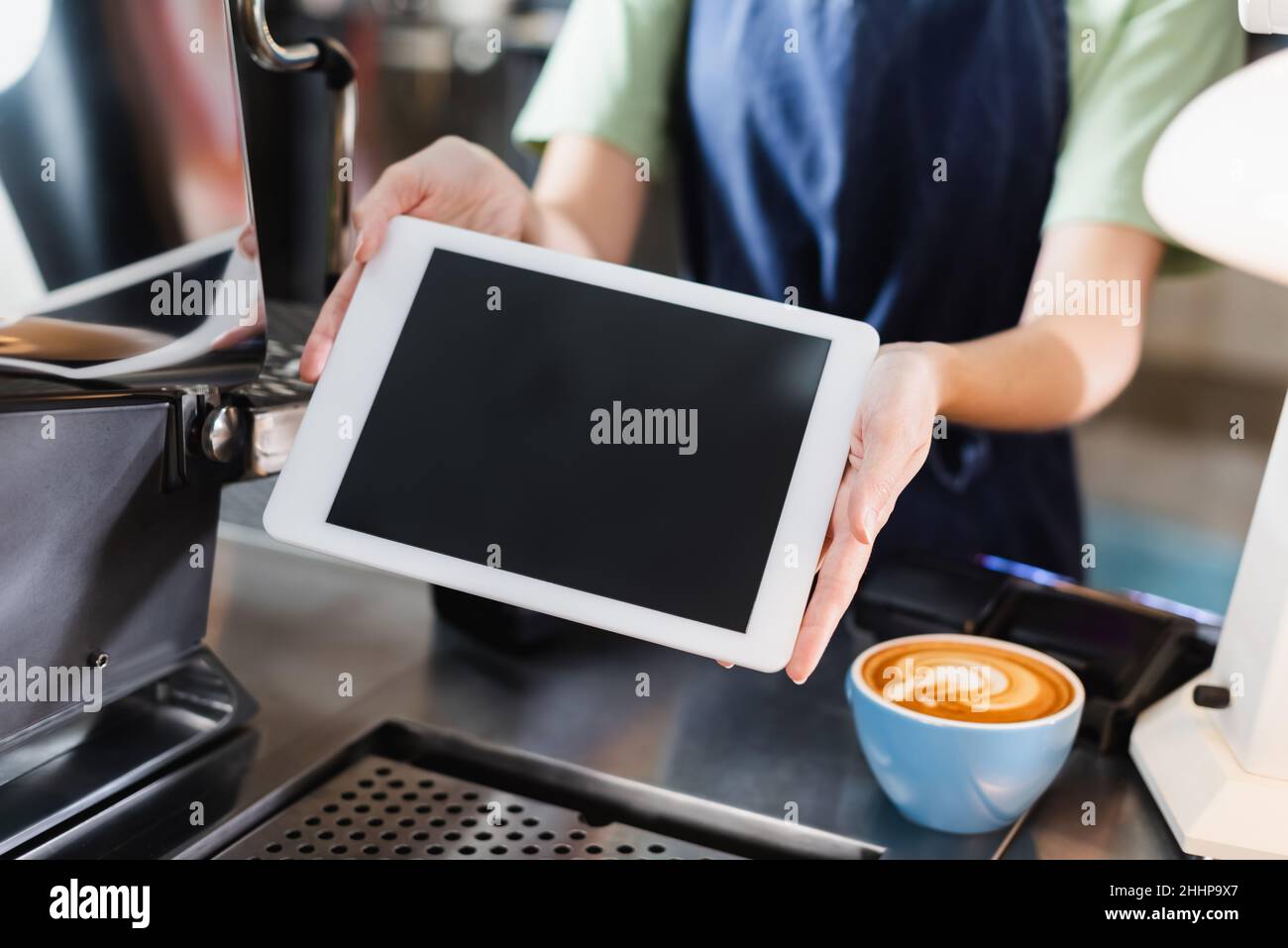 Cropped view of barista holding digital tablet with blank screen near ...