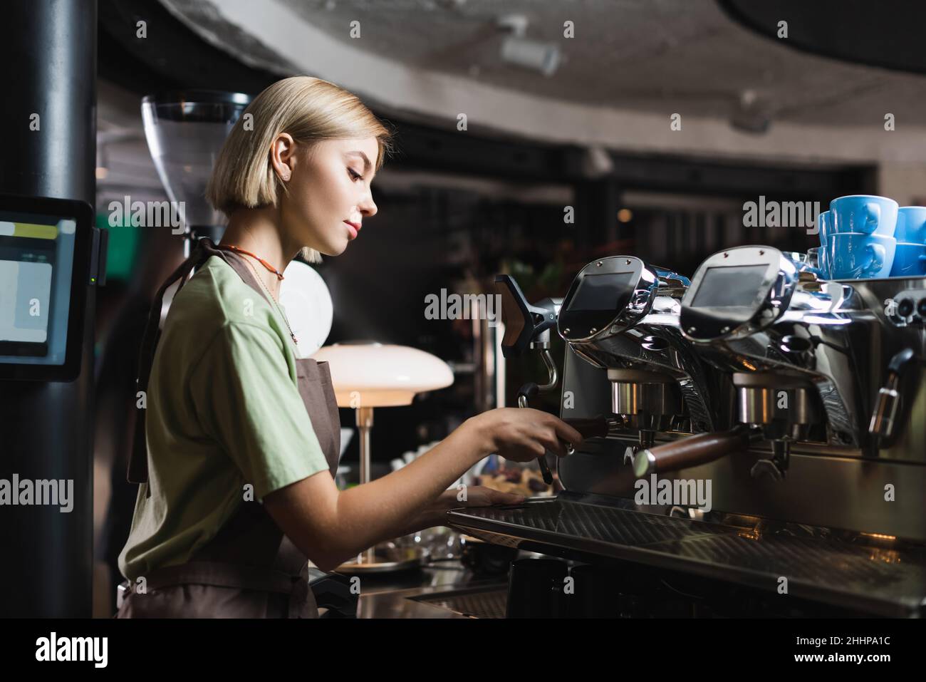 Side view of young barista working with coffee machine in cafe Stock ...
