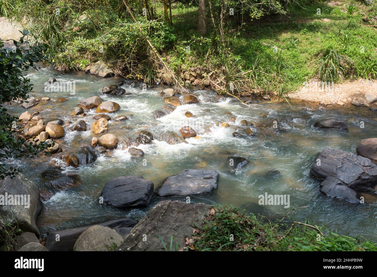 clean water flowing in a stream through large rocks and stones ...