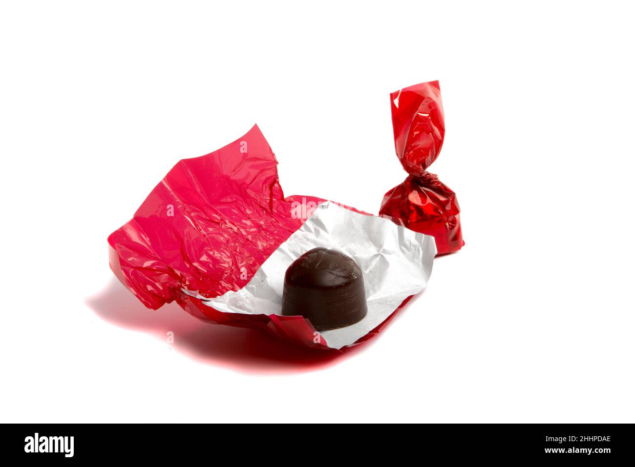 Sweets in red foil isolated Stock Photo - Alamy