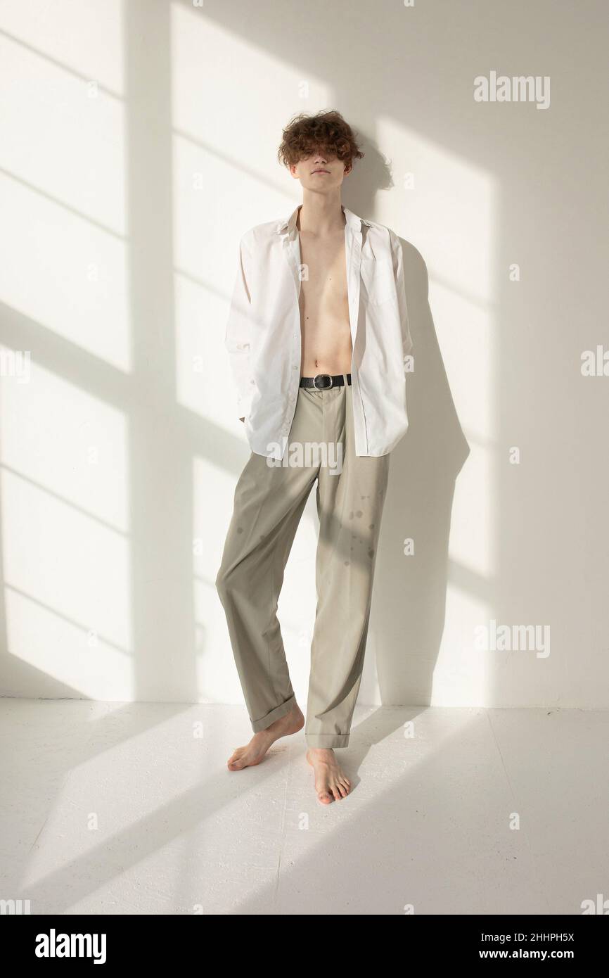 Barefoot attractive young european man with window shadow on wall Stock ...