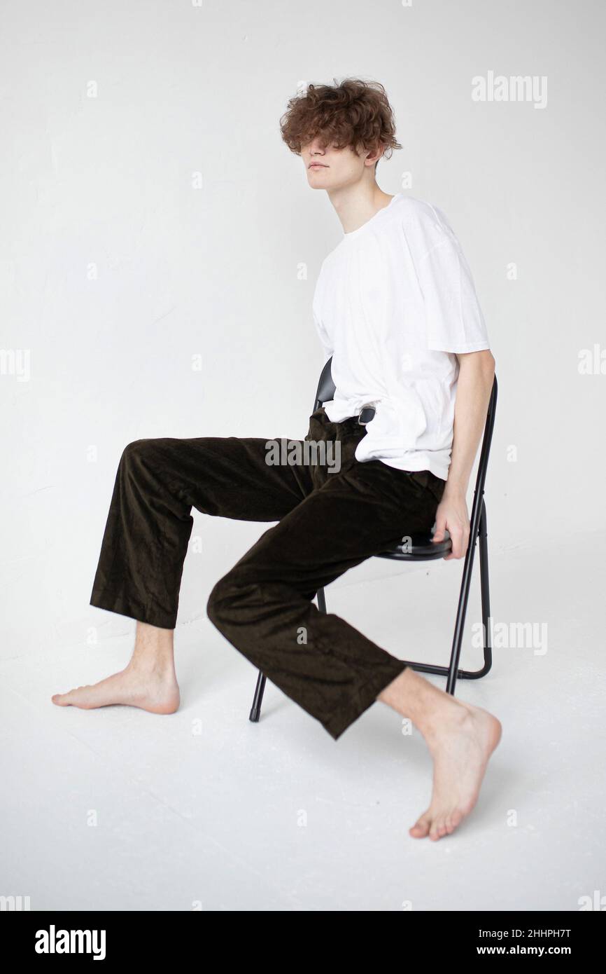 Sitting attractive young european man with hair covered his face ...