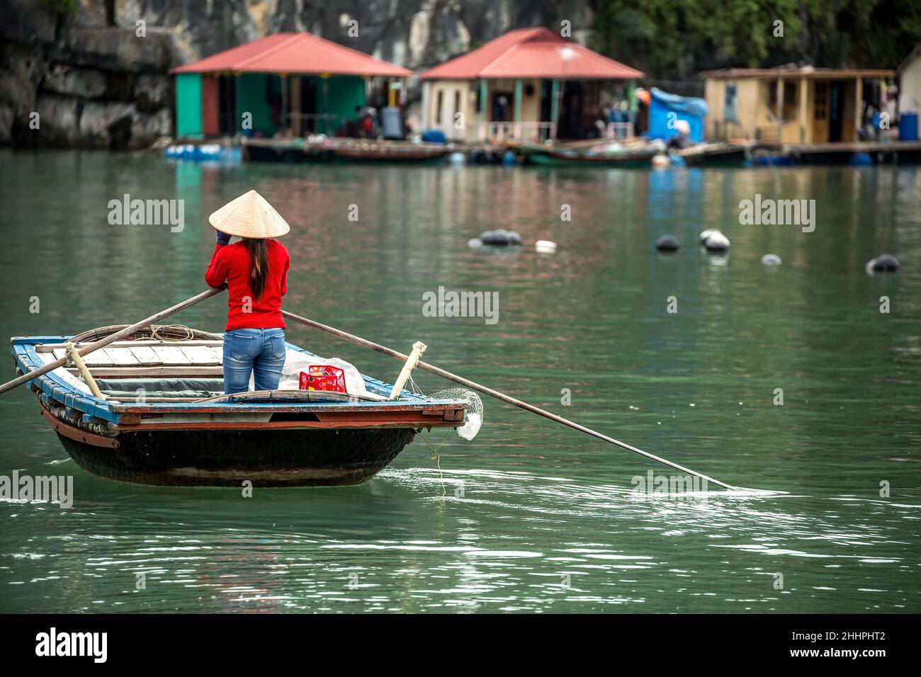 Woman rowing wooden rowboat and floating houses, Vung Vieng fishing ...