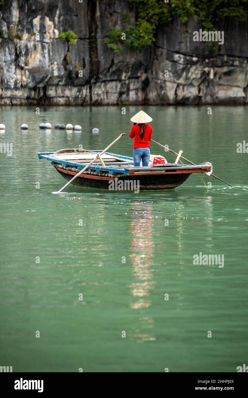 Woman rowing wooden rowboat and pearl farm buoys, Vung Vieng fishing ...