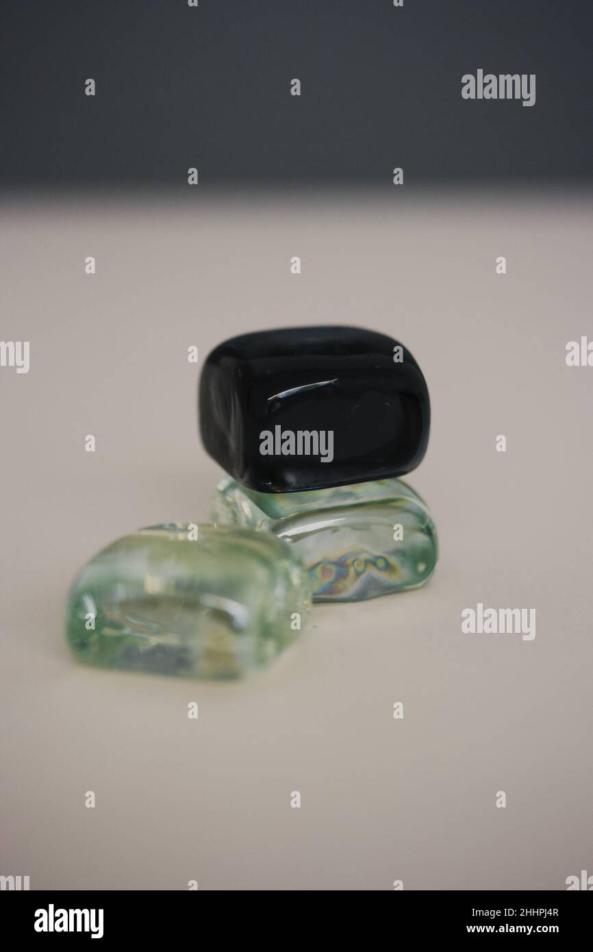 close-up glass cubes on a white background. One black glass stone ...