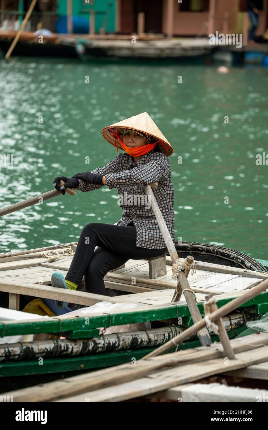 Woman rower wearing rice paddy straw hat, Vung Vieng fishing village ...