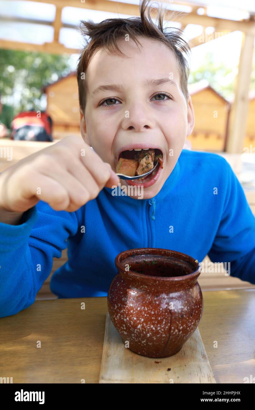 Hungry boy eating pot roast in restaurant Stock Photo - Alamy