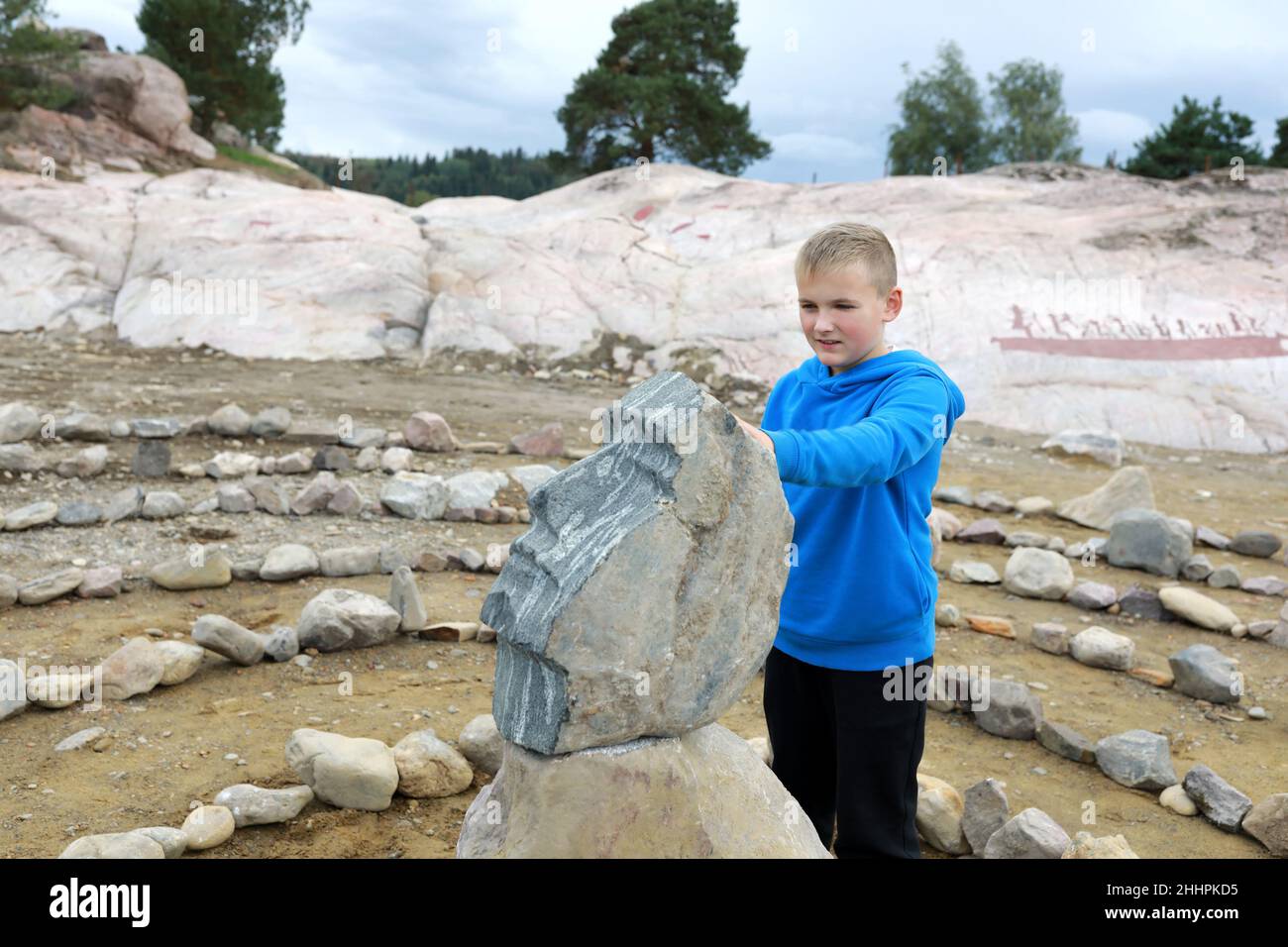 Child touching face carved in stone, Karelia Stock Photo - Alamy