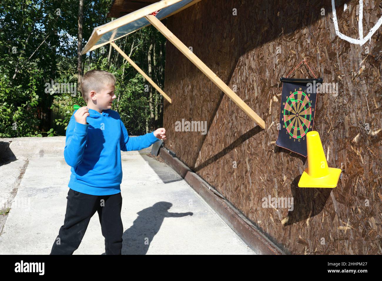 Child playing darts at backyard in summer Stock Photo - Alamy