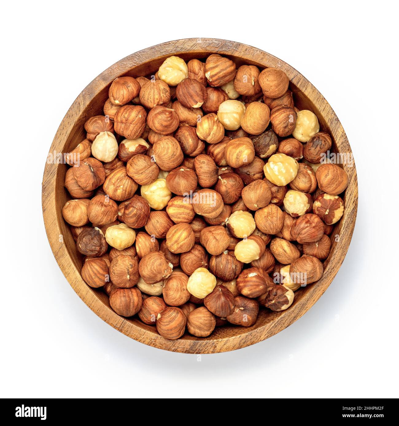 Peeled hazelnuts in wooden bowl isolated on white background top view ...
