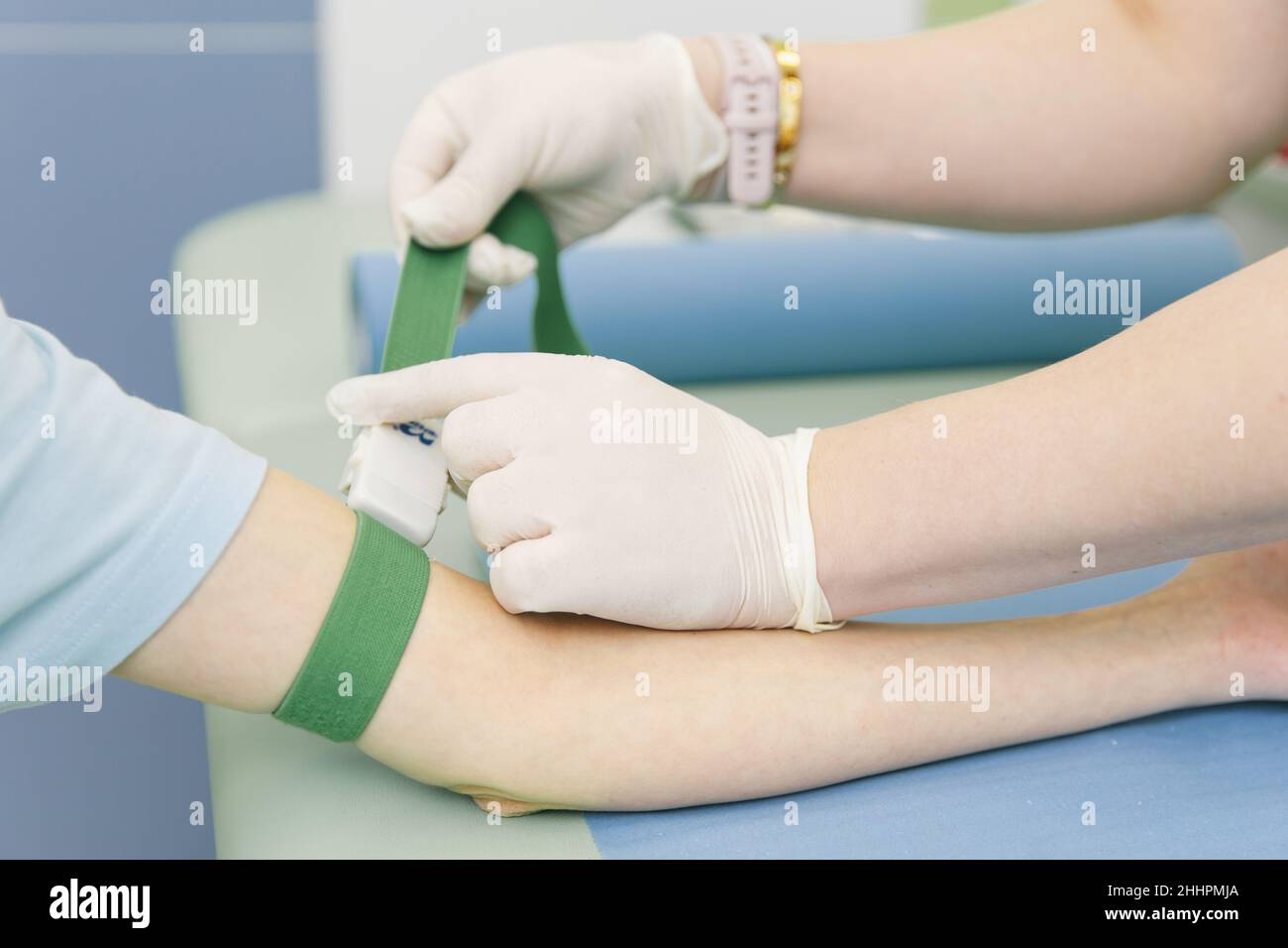 Taking a blood test from a vein in the treatment room. Nurse pricking a ...