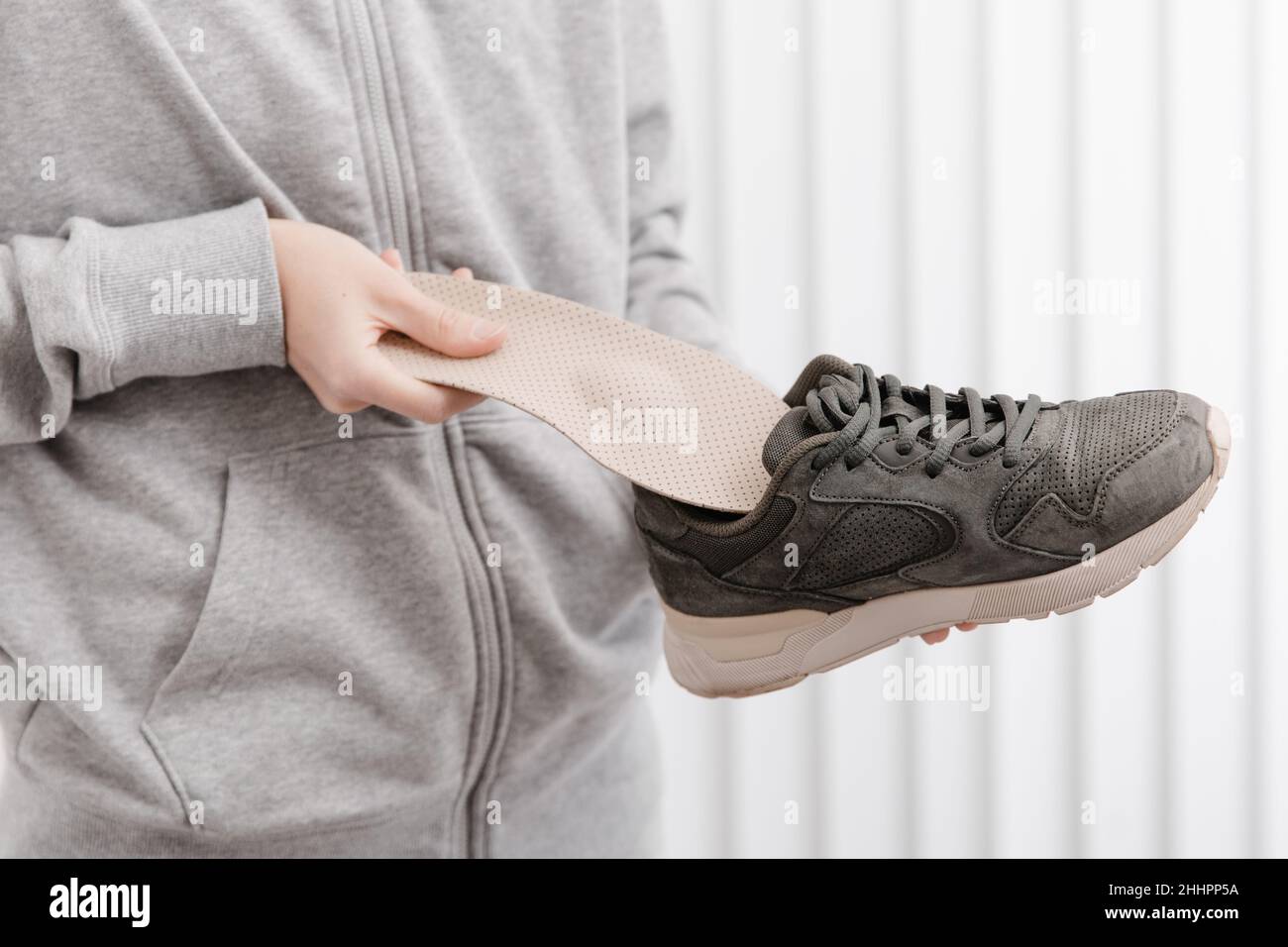 Woman putting orthopedic insole into shoe at home. Sports girl fitting ...